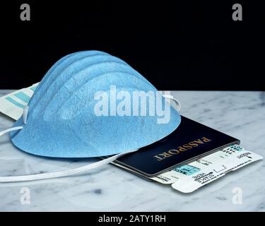 A disposable particle mask rests on a passport containing an airline ...