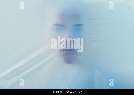 Human face pressing through fabric as horror background Stock Photo - Alamy
