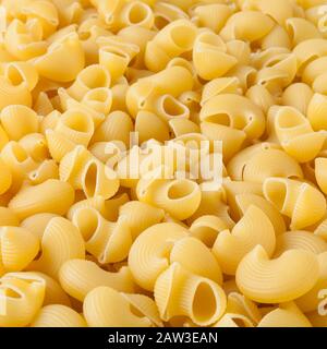 Top view of yellow uncooked pipe rigate snail shape Italian pasta ...
