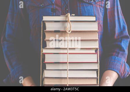 A man holds many books tied with a rope Stock Photo - Alamy