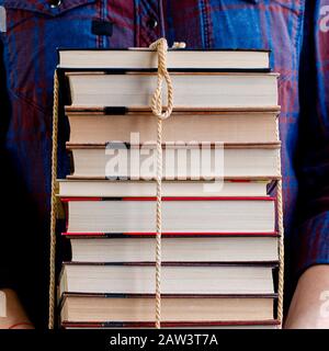 A man holds many books tied with a rope Stock Photo - Alamy