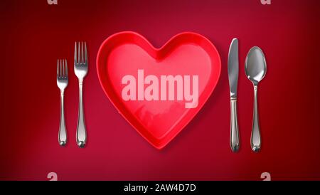 heart shape plate ,spoons ,forks, knife on red background Stock Photo ...