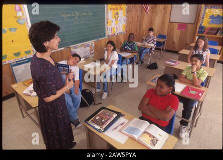 Fourth grade elementary school teacher using an overhead projector in ...