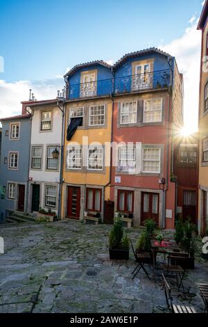 Historic stone paved street with pastel facades shops and narrow alley ...