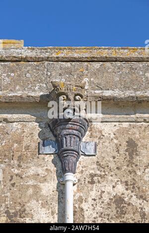 Gargoyle grotesque face drainpipe on wall medieval church of Saint John ...