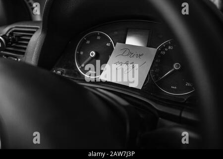 Writing drive safely on memo post reminder. Text on sticky paper inside ...