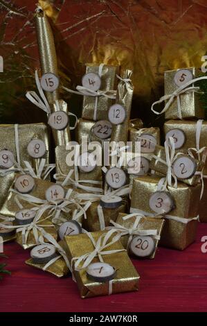 Four wrapped Christmas presents on wooden floor near burning fireplace ...
