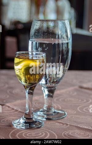 Brandy glass with ice on green background Stock Photo - Alamy