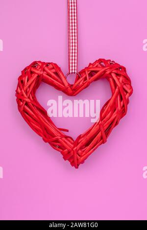 Heart made of pink ribbon on beige background with space for text ...