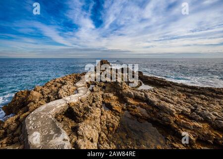 Cap d'Antibes rough sea waves splashing on the cliffs Stock Photo - Alamy