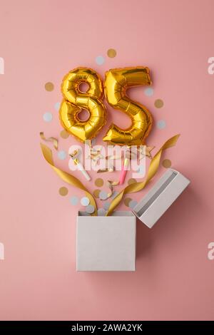 Confetti explosion with number 85 balloon - Celebration on orange ...