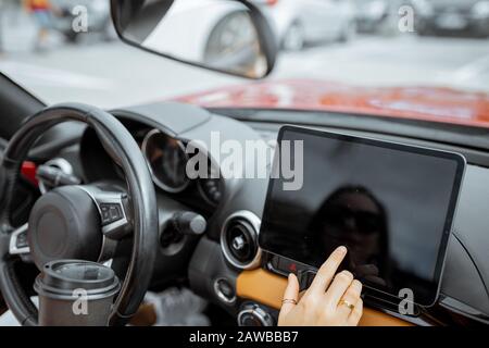 Woman touching a smart car concept on a touch screen with her finger ...