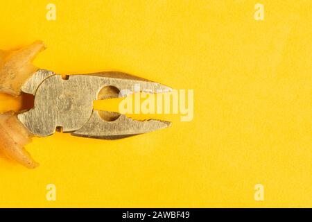 Pliers with orange handles on yellow background. work tool. copy space ...