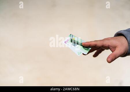 Man hand giving money like a bribe or tips. Holding EURO banknotes on a ...