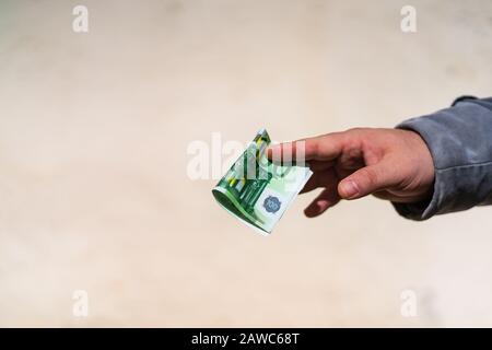 Man hand giving money like a bribe or tips. Holding EURO banknotes on a ...