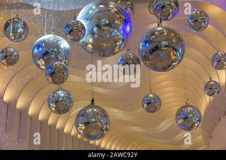 Large silver balls hang from the ceiling of the walkways of the ...