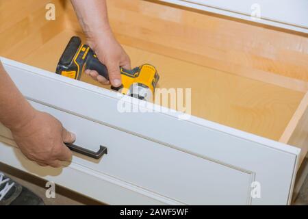 Installation of measuring drawers handles on kitchen cabinets Stock ...