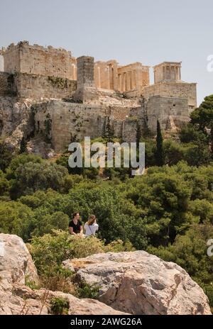 Greece, Athens. Tourist couple at Acropolis. Two people at Parthenon ruins. Travel and tourism ...