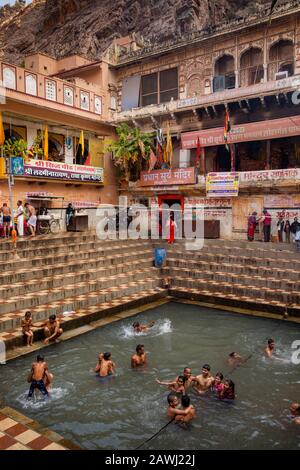 Indian Hindu pilgrims men and boys bathing in The Ganges River by steps ...