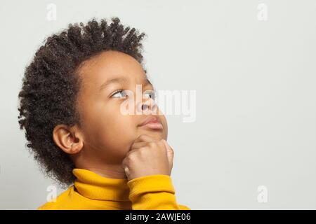 Clever black child thinking on chalkboard background with science ...