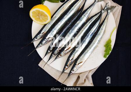 raw fresh needlefish (belonidae family) on the plate ready to cook ...