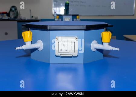 Science laboratory table of gas nozzles and electricity on a blue empty ...
