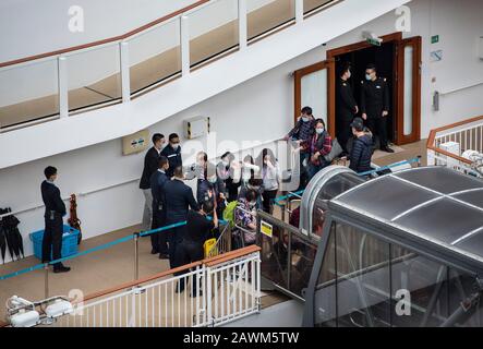 Passengers queue up to finally disembark from the World Dream cruise ...
