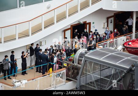 Passengers queue up to finally disembark from the World Dream cruise ...