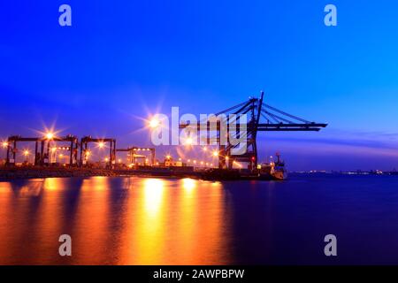 Freight dock of container crane at night Stock Photo - Alamy