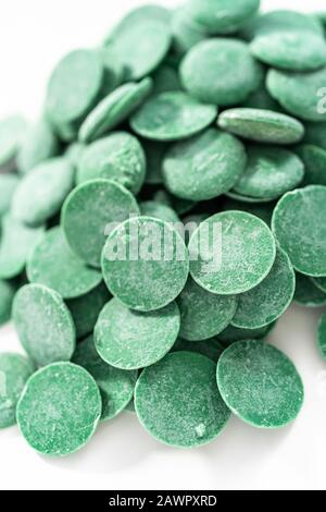 Green round chocolate chips for melting chocolate shapes on a white ...