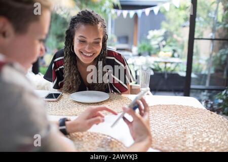 Young women show a mobile phone Stock Photo - Alamy