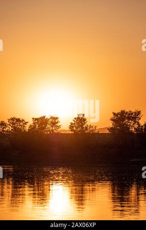 A vertical shot of the sun's reflection at sunset on a modern building ...