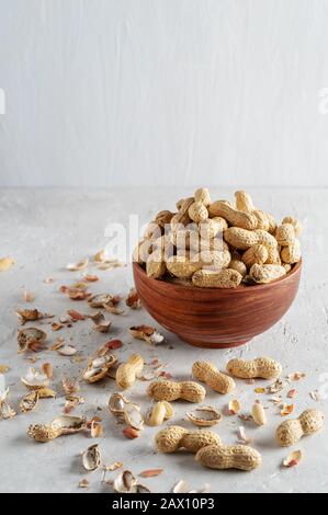 Peanuts in a eco, wooden container isolated on wooden background. Pile ...