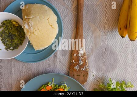 Traditional East African food - ugali, fish and greens in Kenya Stock ...