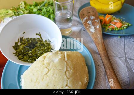 Traditional East African food - ugali, fish and greens in Kenya Stock ...