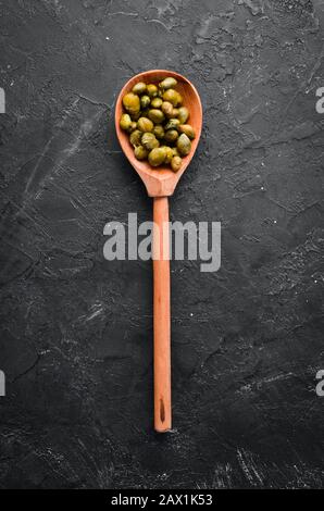 Organic capers in a white bowl on a rustic kitchen table, healthy food ...