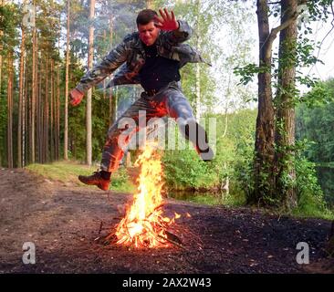 A man jumping in the lake shore Stock Photo - Alamy