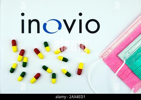 Inovio Pharmaceuticals logo on the brochure, pills, syringe and viral masks. Flat lay Stock ...