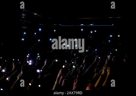 Group of people holding cigarette lighters at a concert Stock Photo - Alamy