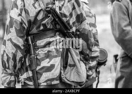 man in black costume with submachine gun (SMG) isolated on white ...