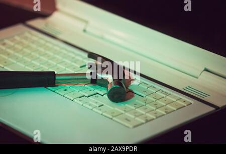 old broken laptop with hammer on keyboard isolated on white background ...
