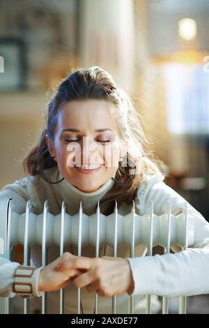 Happy Woman At Home With Warm Radiator Heater Stock Photo - Alamy