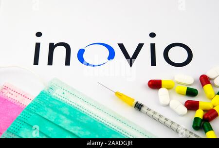 Inovio Pharmaceuticals logo on the brochure, pills, syringe and viral masks. Flat lay Stock ...