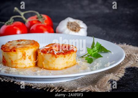 Italian rondelli with pomodoro sauce and cheese on rustic background ...
