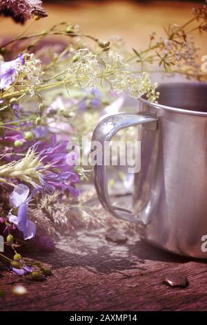 Flowers in an iron mug on the wooden background. Toned image Stock ...