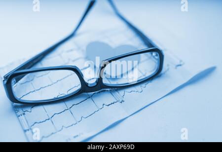 Cardiogram chart with medical stethoscope and small red heart on table ...