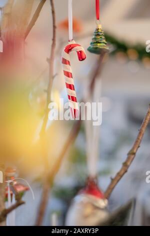 Glass with Christmas balls and candy canes on wooden background with ...