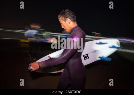 Surfers going surfing at night with neon surfboards Stock Photo - Alamy