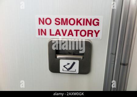 Airplane toilet door with No Smoking warning signs beside an ashtray ...