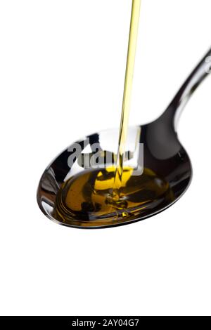 olive oil poured on a spoon over black background Stock Photo - Alamy